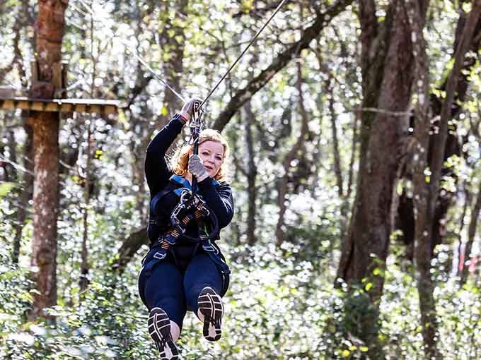 Flying through the canopy with a grin that says she's found the antidote to another boring Saturday afternoon.