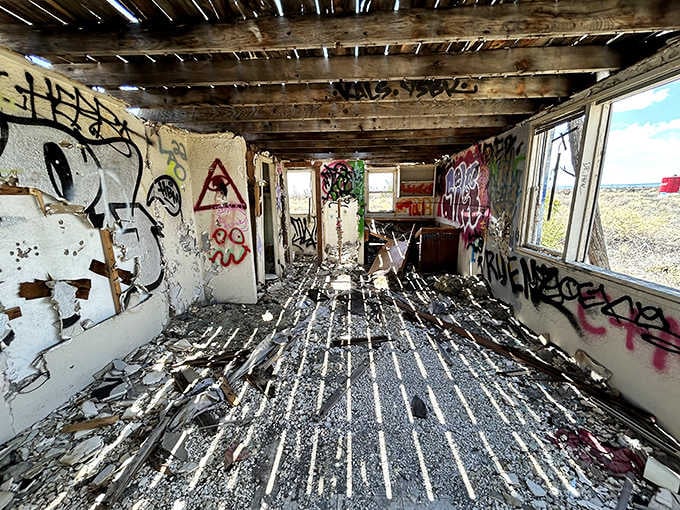 Sunlight streams through broken windows, illuminating what remains of this once-bustling desert oasis.