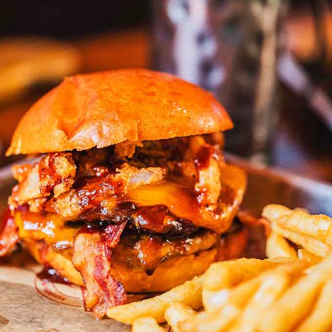 Bacon, caramelized onions, and that golden bun create a burger that looks like it walked straight out of a food dream.