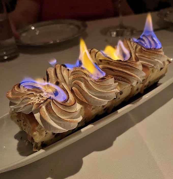 Baked Alaska arrives at your table literally on fire, because sometimes dessert needs to make a dramatic entrance worthy of applause.