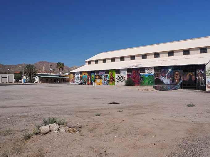 Vibrant murals transform this desert building into an outdoor art gallery celebrating creativity and community spirit.