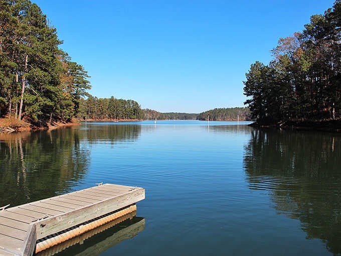 Mirror-smooth water reflects the shoreline perfectly, beautiful and serene yet somehow unsettling in its absolute stillness and silence.