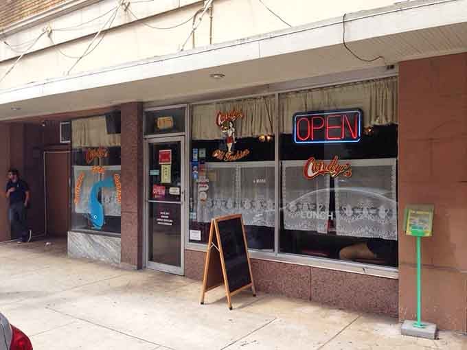 Lace curtains and a glowing neon sign create an inviting storefront that whispers of simpler, sweeter times.