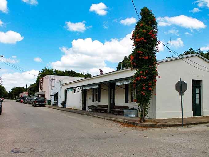 The climbing roses on that corner post add a splash of color to this simple white building's timeless appeal.