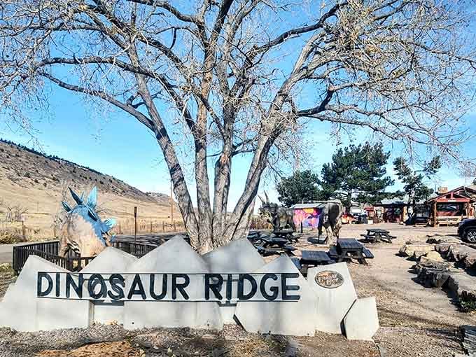 The cheerful entrance sign welcomes visitors to walk among giants, where prehistoric footprints wait just beyond that shady tree.
