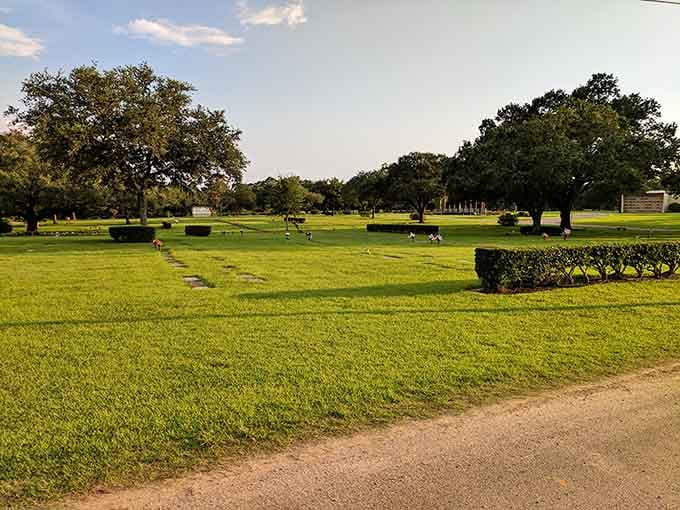 Manicured lawns and trimmed hedges create an almost park-like setting where colorful flowers brighten the peaceful, tree-shaded grounds.
