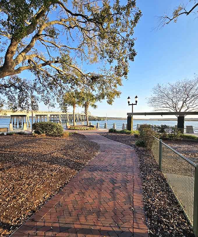 Brick pathways wind along the waterfront where live oaks and Spanish moss frame views that belong on postcards.
