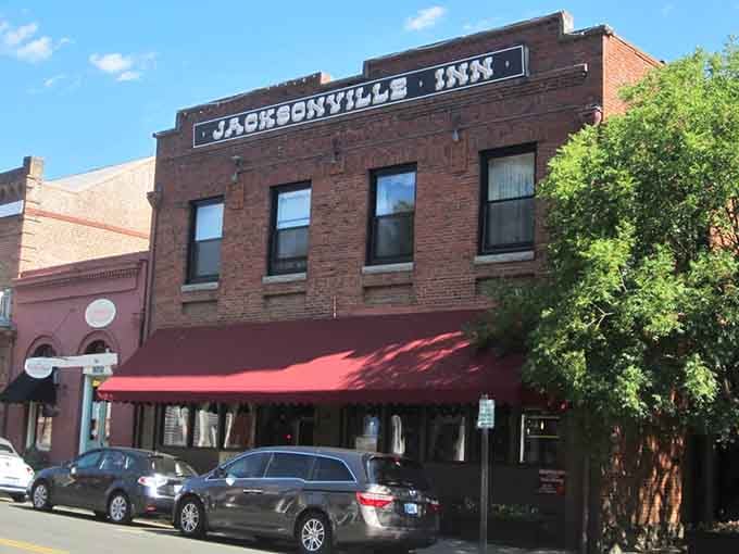 Classic brick architecture meets small-town charm under that cheerful red awning, beckoning travelers since Oregon's gold rush days.