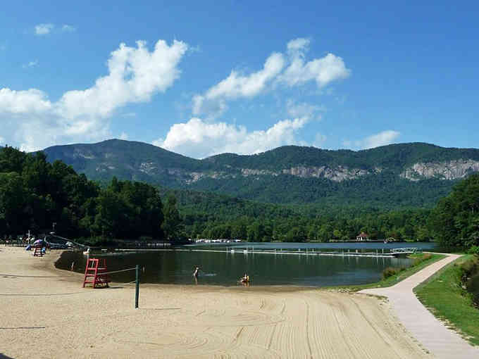 Mountains frame the sandy beach like a postcard, proving paradise doesn't require a plane ticket.