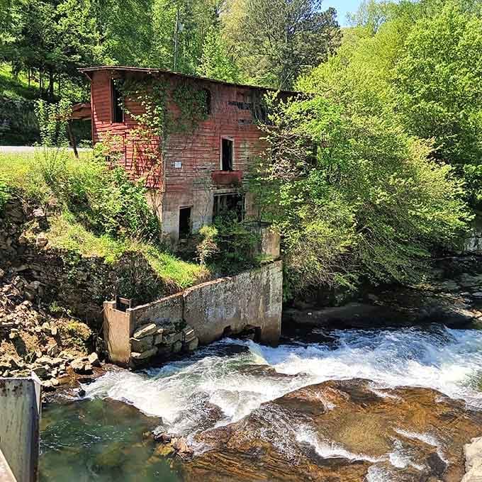 The old red mill stands proud beside rushing water, a beautiful reminder of how communities once gathered and worked.