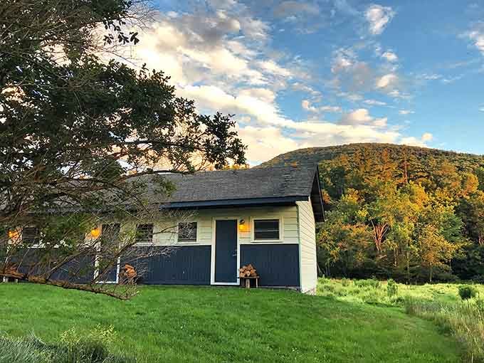 Golden hour bathes this simple mountain building in warm light, with autumn's paintbrush coloring the hillside behind in brilliant orange and yellow.