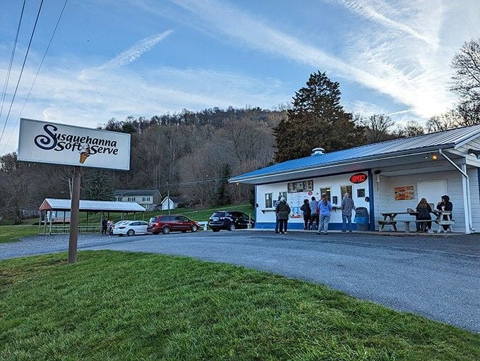 The simple white building with blue trim sits peacefully along the road, a classic American ice cream destination.