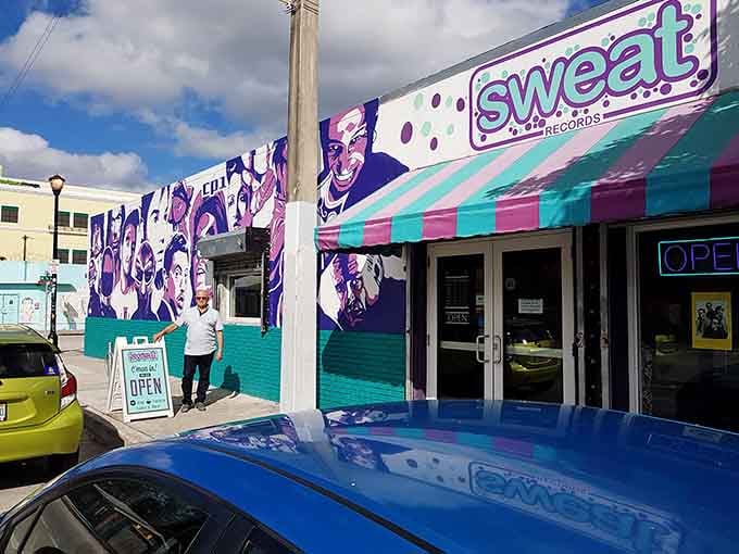 That vibrant mural practically dances off the wall, celebrating music legends in purple and teal Miami sunshine glory.