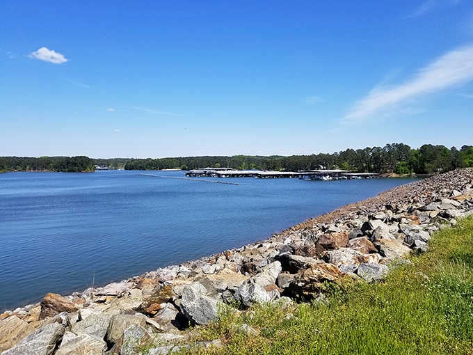 The rocky dam holds back deep blue water and deeper secrets, a massive wall between present and drowned past.