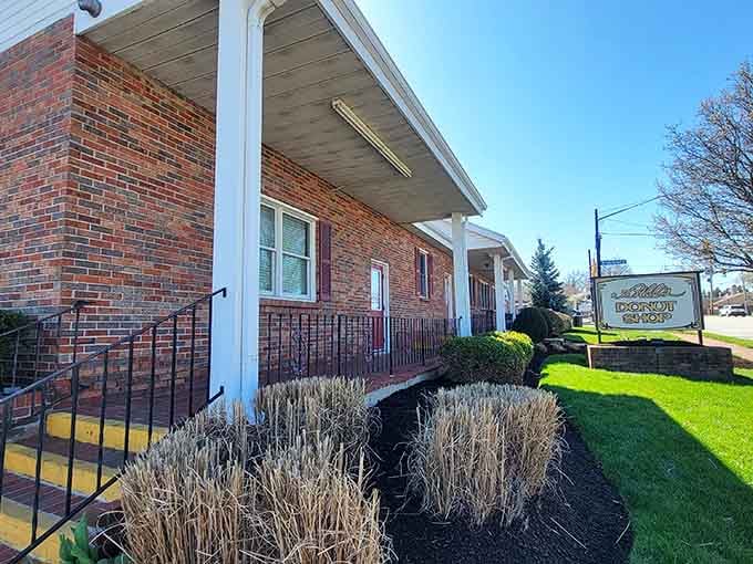 The classic brick facade with white trim looks like it could be someone's beloved home, serving comfort one donut at a time.