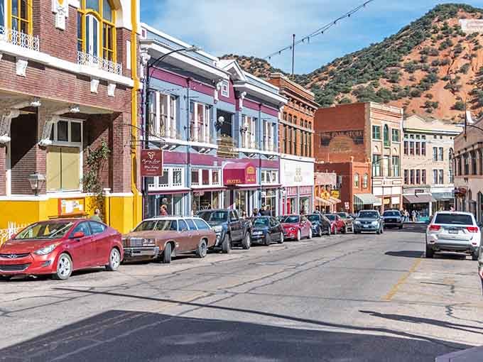These painted storefronts pop against mountain greenery, creating a postcard-perfect scene that cameras absolutely love.
