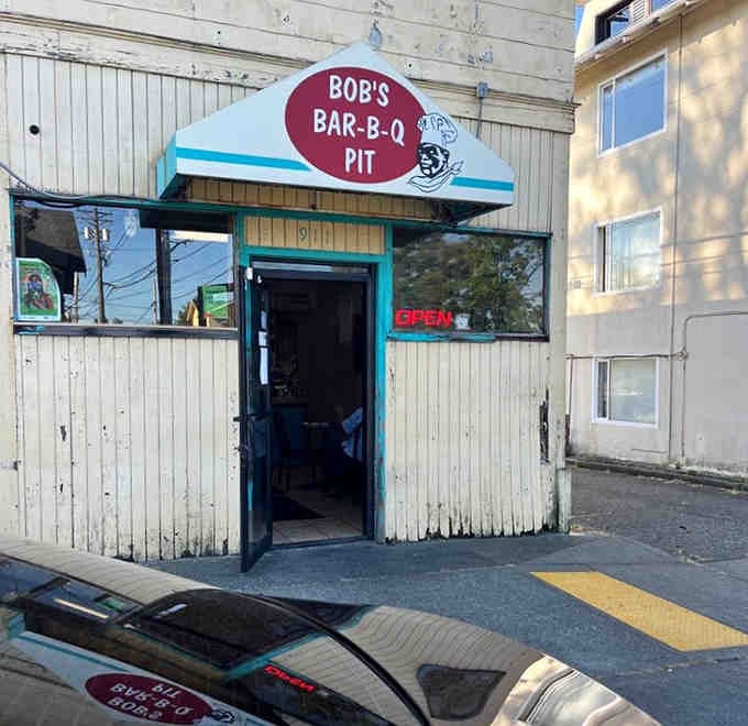 The weathered exterior tells stories of countless satisfied customers who've walked through that door seeking smoky salvation and found it.