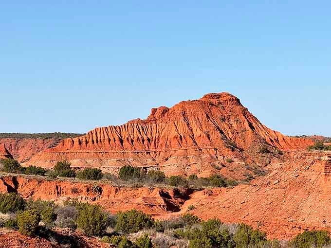 The striped formations glow orange and crimson under blue skies, proving that nature's palette beats any artist's studio hands down.