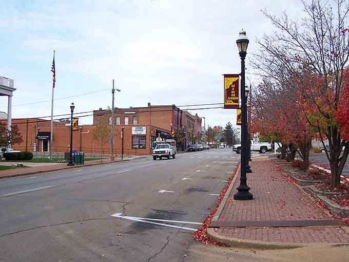 Autumn leaves frame the quiet street, where decorative lampposts and brick sidewalks invite leisurely strolls through downtown's heart.