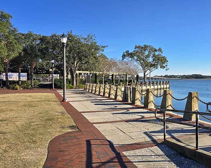 Chain-lined walkways lead to the water's edge, where benches invite you to sit and watch the river flow by.