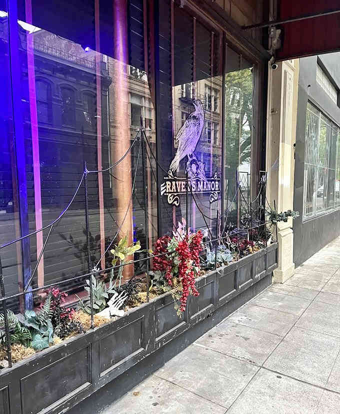 Purple-lit windows and mysterious storefront gardens hint at the enchanting gothic atmosphere waiting inside this urban manor.