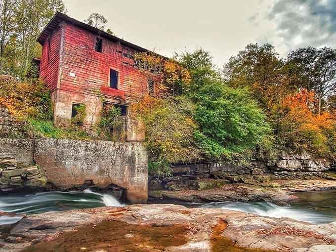 Autumn colors frame this weathered structure where creek water still flows over rocks worn smooth by time.