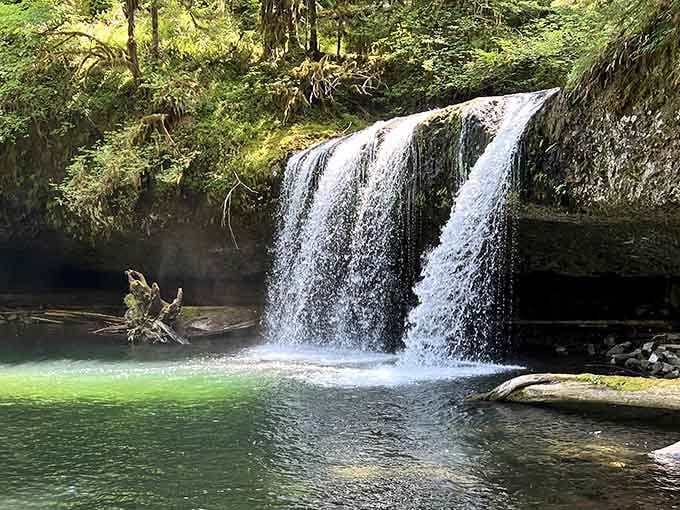 That pool glows like liquid jade, fed by twin curtains of water in this peaceful forest sanctuary.