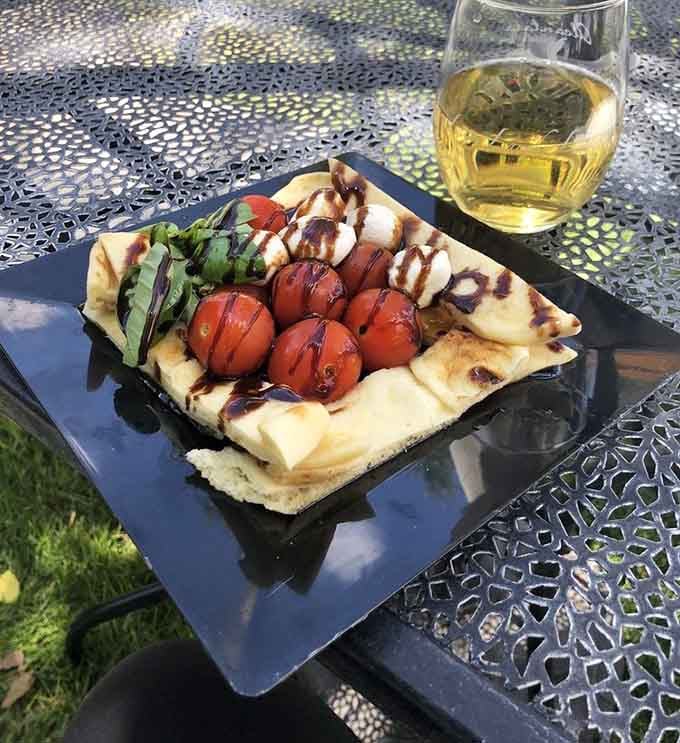 Caprese flatbread paired with white wine is the kind of sophisticated snack that makes you feel instantly more cultured.