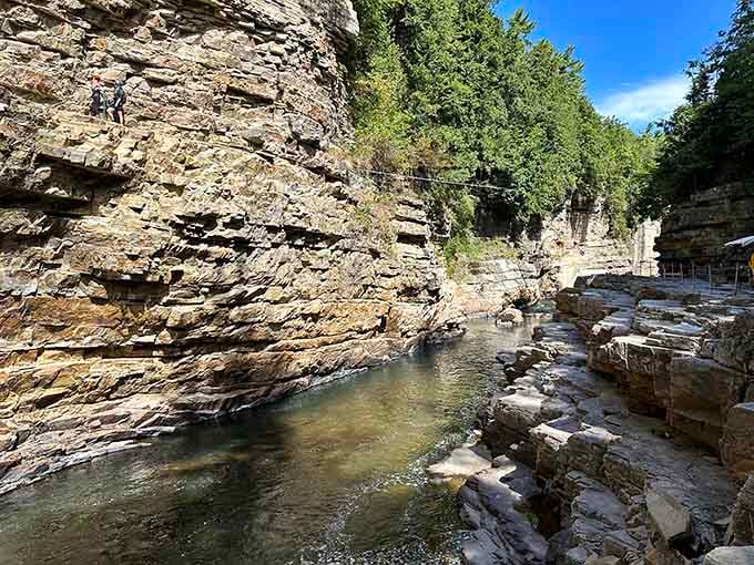 Clear water flowing over layered rock, doing what it's done for millennia while you get the Instagram glory.