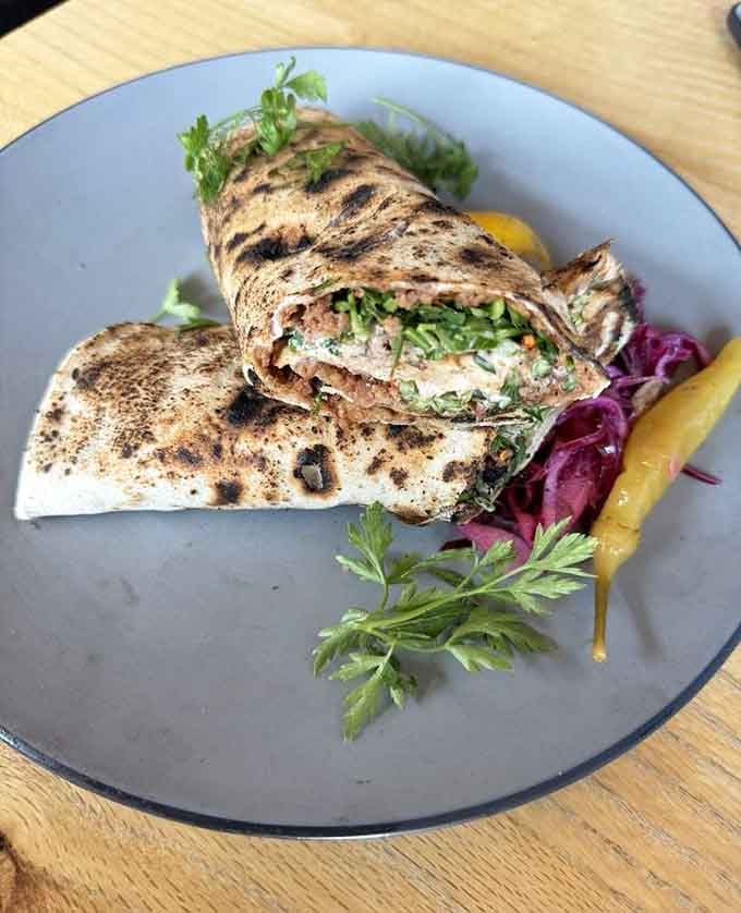 The lahmacun gets rolled up tight with fresh greens peeking out, making healthy eating look downright exciting for once in your life.