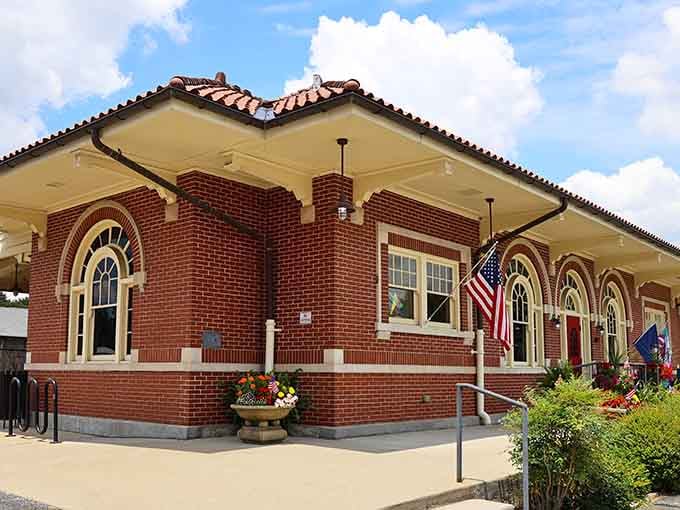 The historic depot stands proud with flowers blooming, a charming reminder of when train travel was the height of sophistication.