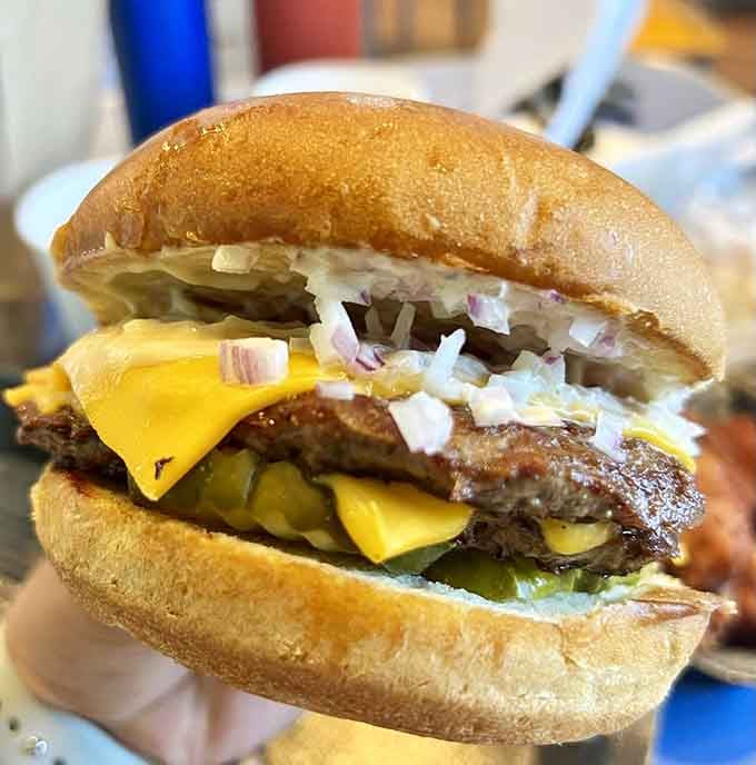 Two juicy patties on a brioche bun with pickles and onions, this burger means serious business in the best way.