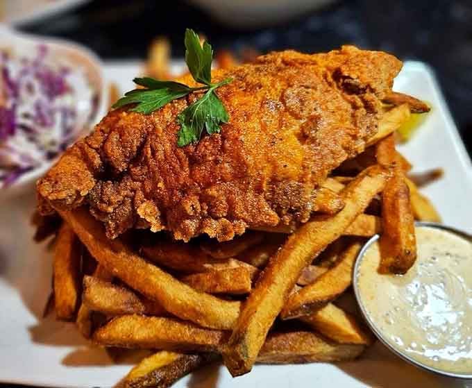 Golden, crispy fish perched on fries like edible architecture, tartar sauce standing by for the inevitable dive.