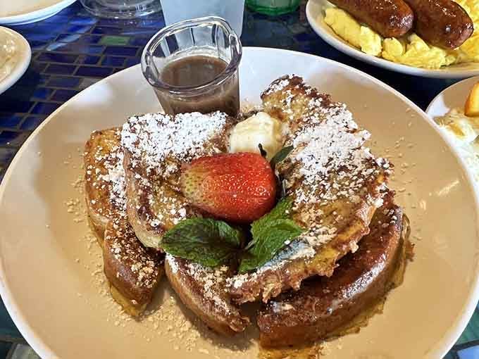French toast arrives looking like it just won best in show, complete with fresh strawberries and whipped cream glory.