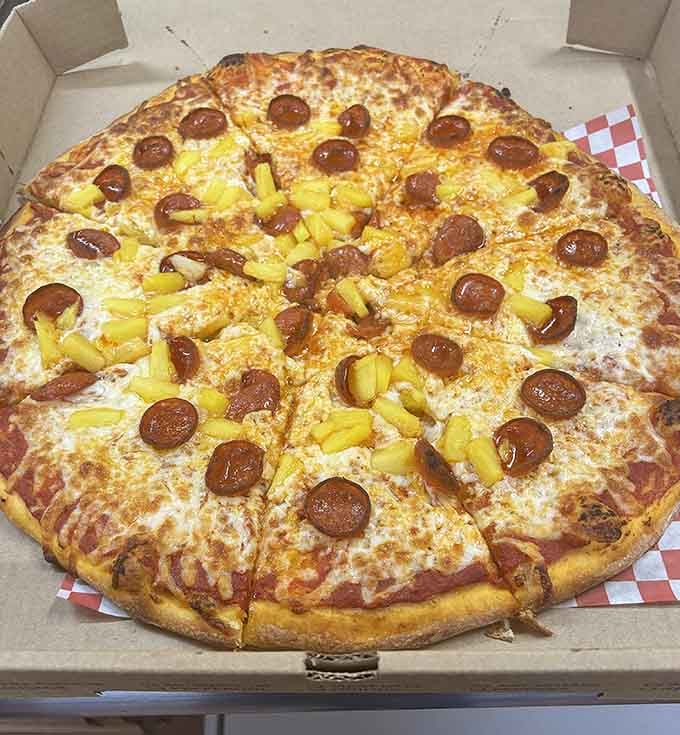 Pineapple and pepperoni share space on this golden masterpiece, proving controversial toppings can create perfect harmony when done right.