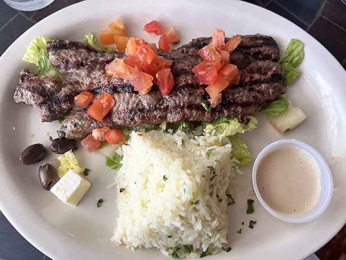 Lamb kafta kabab brings Middle Eastern spices to life with tender, grilled perfection served alongside rice and fresh vegetables.
