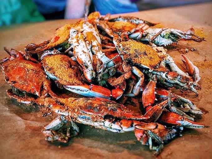 A mountain of steamed blue crabs dusted with Old Bay, looking like edible treasure that requires serious commitment.