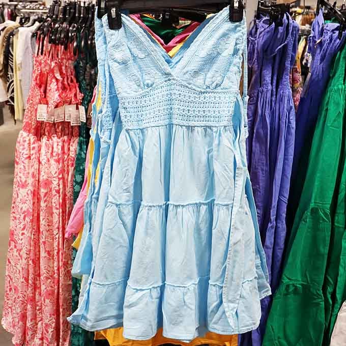 Summer dresses hanging like colorful promises of warmer days, priced so you can actually afford multiple seasonal wardrobes.