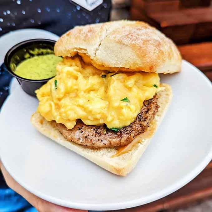 Fluffy scrambled eggs on a breakfast sandwich that understands mornings require both comfort and serious flavor commitment.