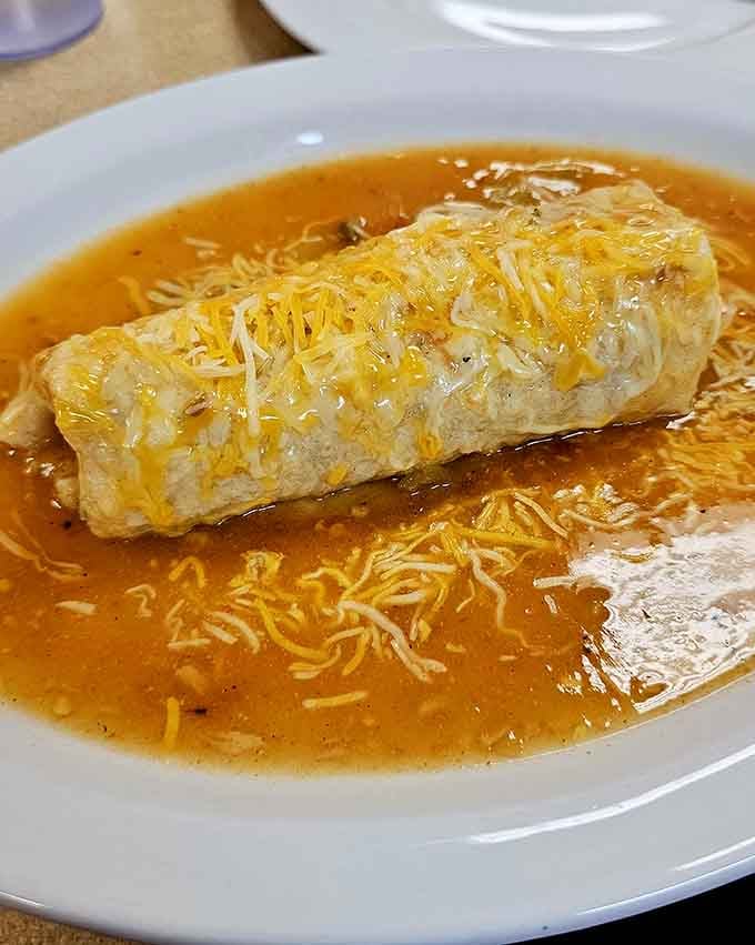 A breakfast burrito smothered in sauce and cheese is basically a warm hug on a plate, and this one's got extra love.