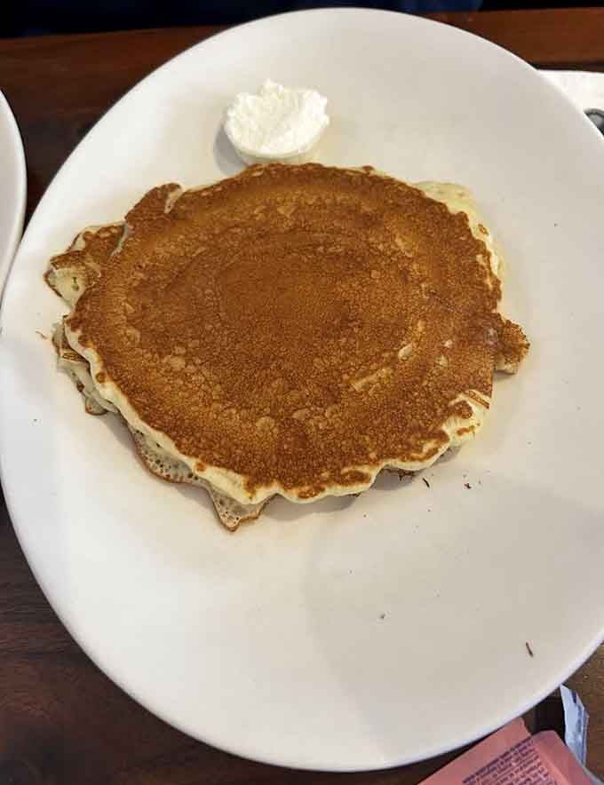 Pancakes so perfectly golden they could make IHOP weep with envy, topped with a cloud of cream.
