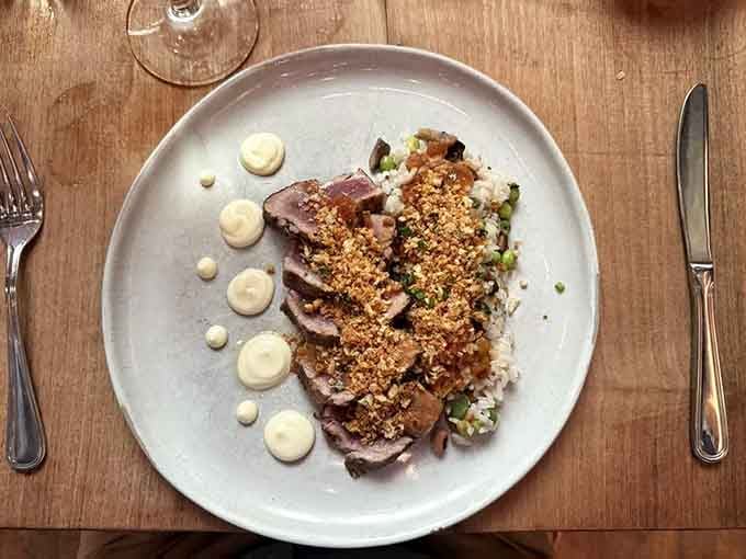 Seared ahi tuna sliced to reveal that gorgeous pink center, plated with artistic flair that matches the stunning surroundings.