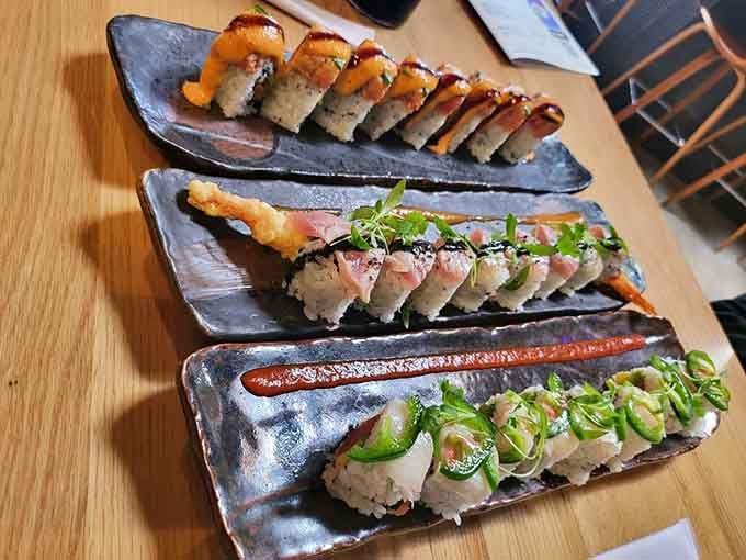 Three different sushi rolls on sleek ceramic plates demonstrate that variety truly is the spice of life, or at least dinner.
