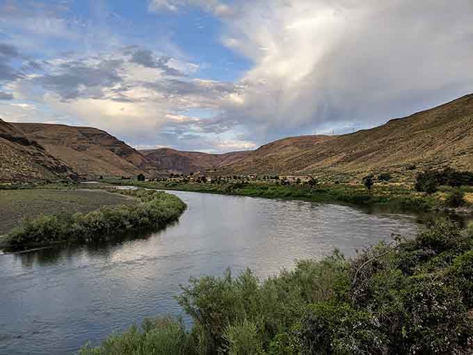 The river reflects dramatic skies while winding through terrain that'll make you forget what rain-soaked Portland even looks like.