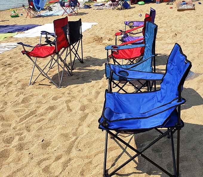 Beach chairs lined up like colorful soldiers, each one claiming its sandy territory for the day ahead.