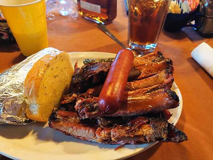 Ribs piled high next to a foil-wrapped potato create the kind of plate that requires strategic planning and serious commitment.