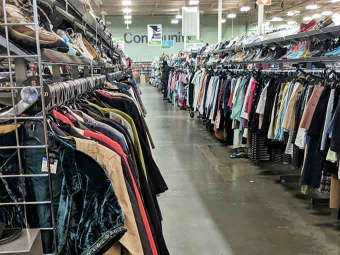 Racks extend into infinity like a fabric rainbow, each hanger holding someone's future favorite shirt or jacket.