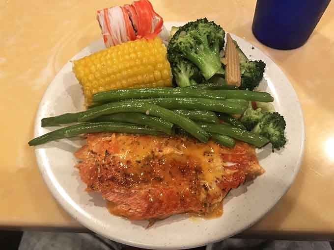 Perfectly grilled salmon surrounded by vibrant vegetables, looking like the healthy choice that actually tastes like a celebration dinner.