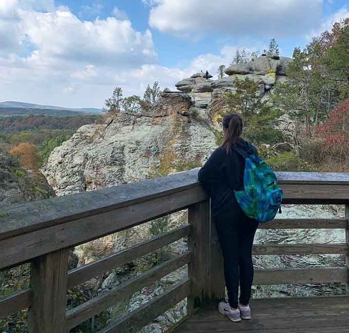 Standing at the railing, she contemplates layers of sandstone that have witnessed more sunrises than we can count.