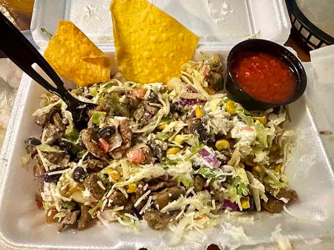 These nachos don't mess around, piled high enough to require architectural planning before your first bite.